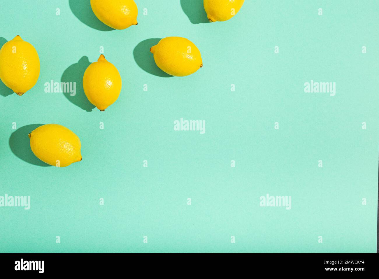 Fresh yellow whole lemons on minimal blue background on bright sun ...