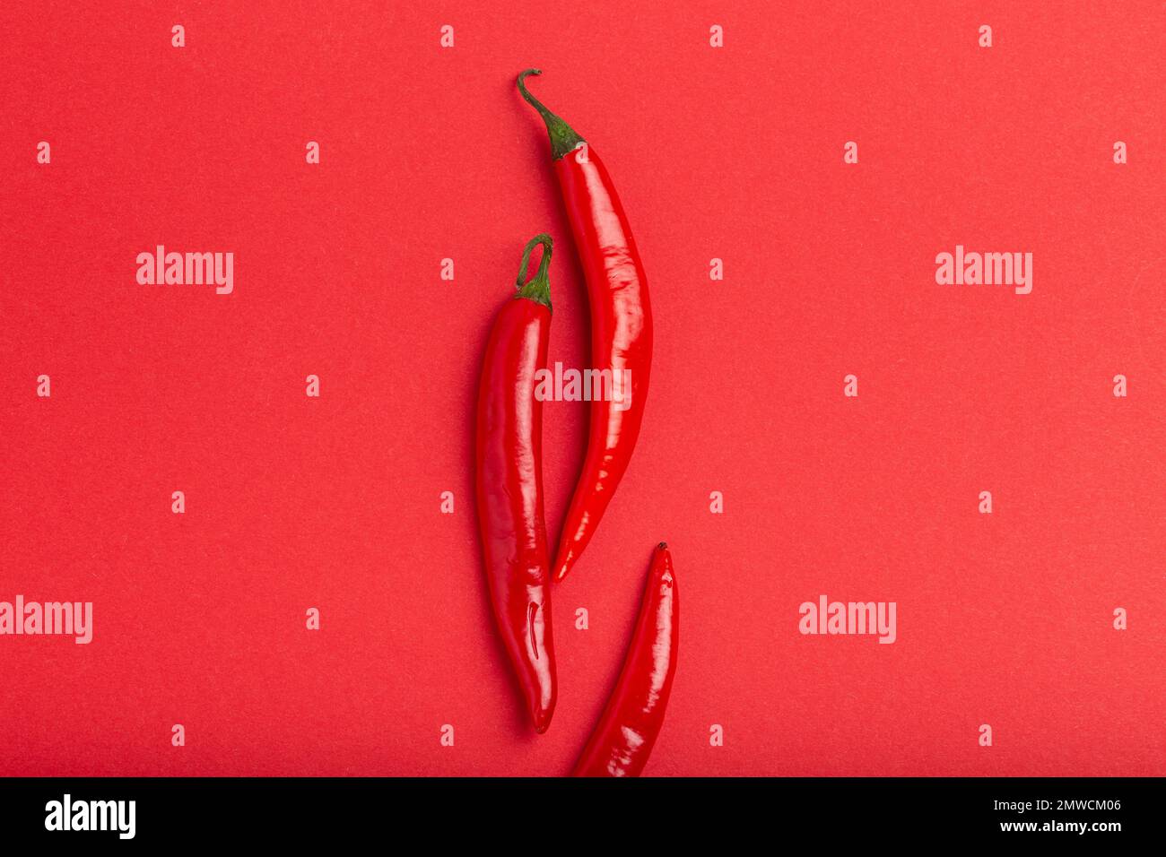 Red hot chilli peppers on minimal red background close up macro flat ...