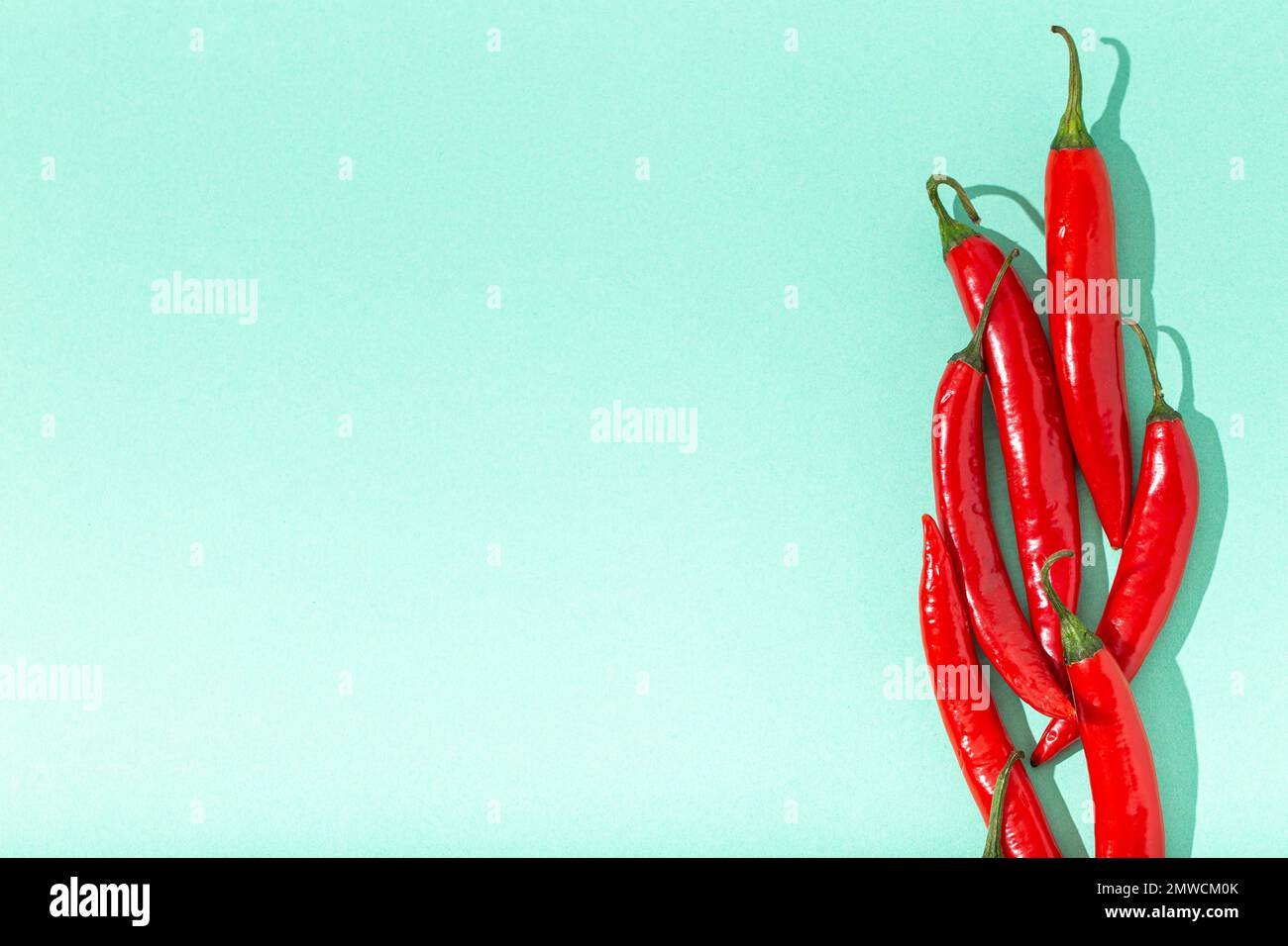 Red hot chilli peppers on minimal blue contrast background close up ...