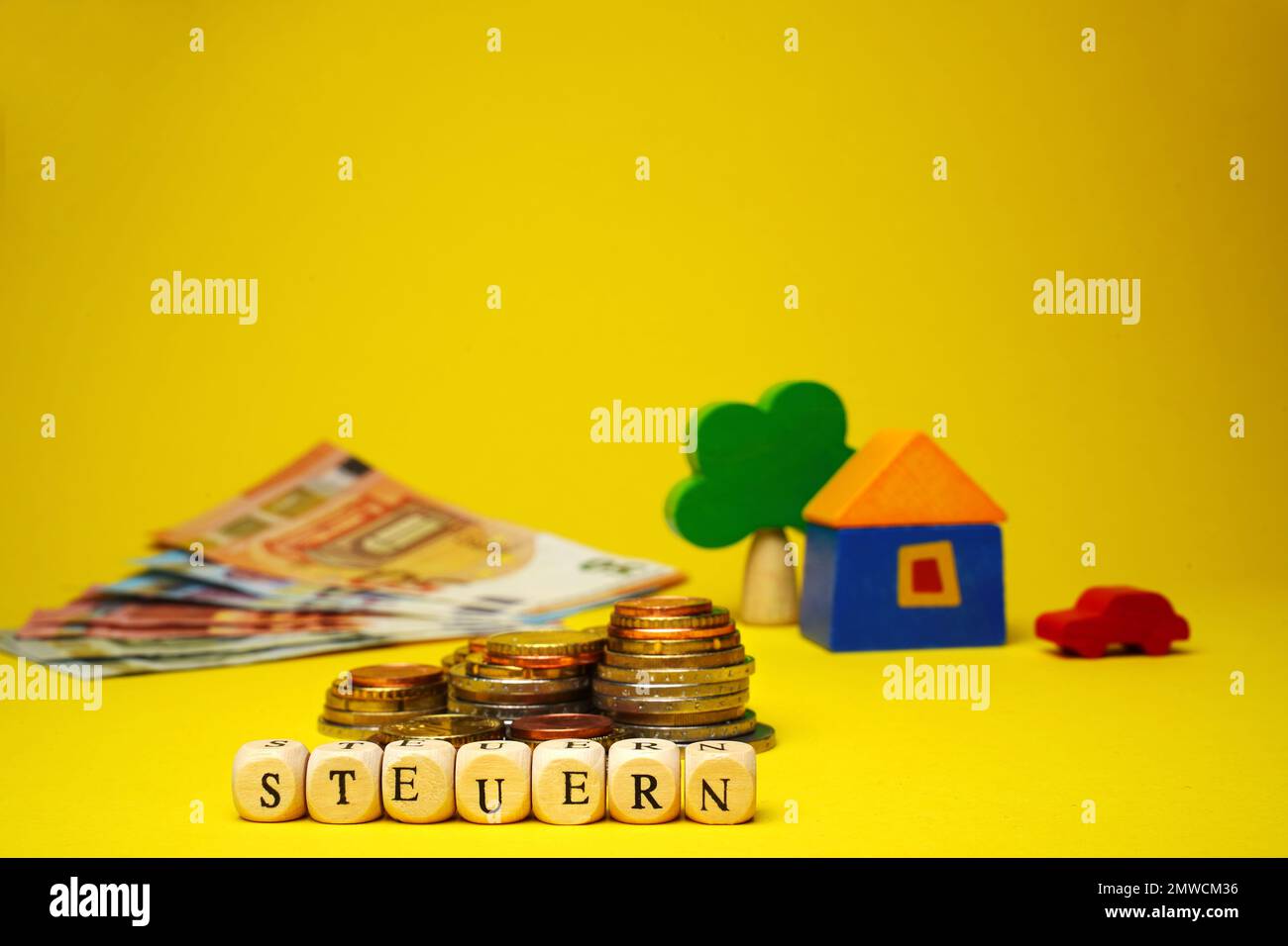 German word for tax, Steuern, from wood cubes with letter. Euro cash ...