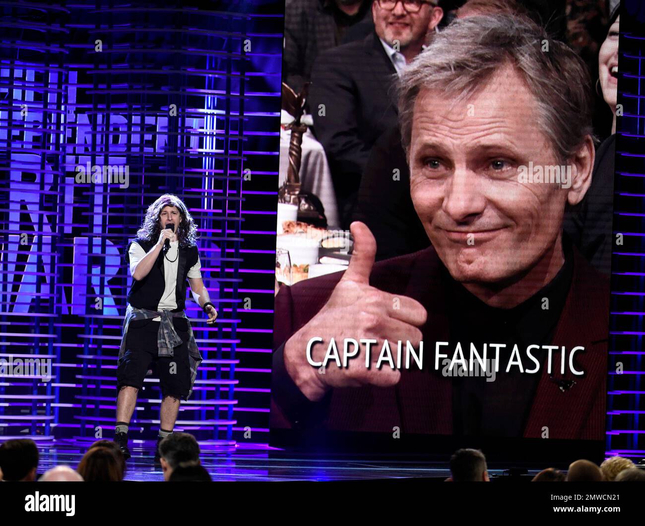 Andy Samberg performs while Viggo Mortensen is seen on screen at the ...
