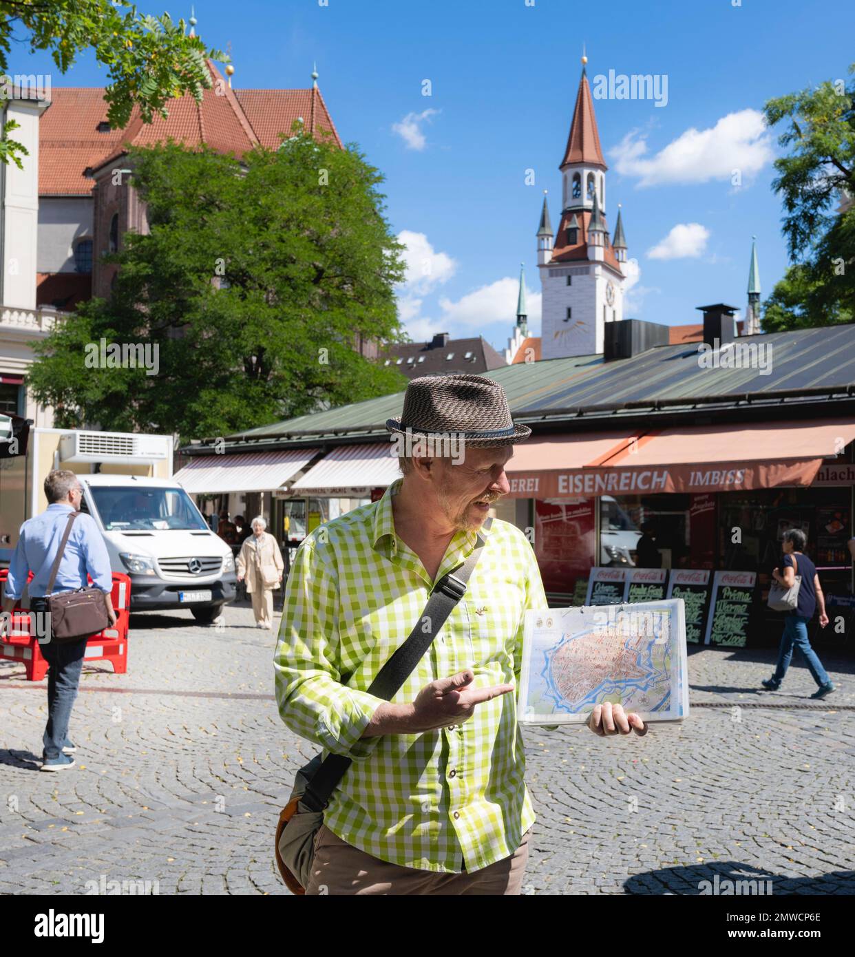 Tour guide with city map on city tour at the Viktualienmarkt, city ...