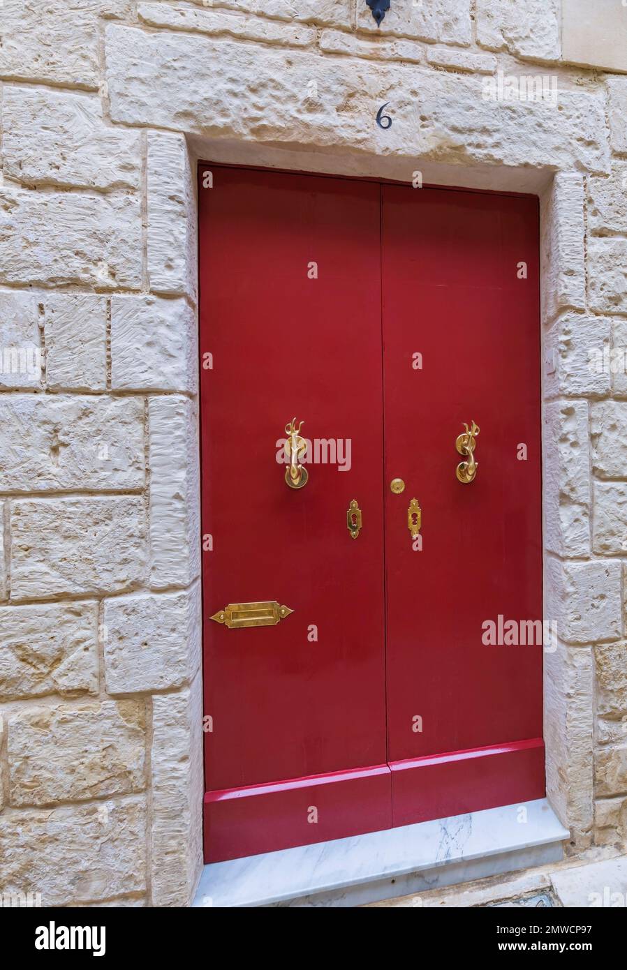 Old red painted wooden entrance door on facade of residential building ...
