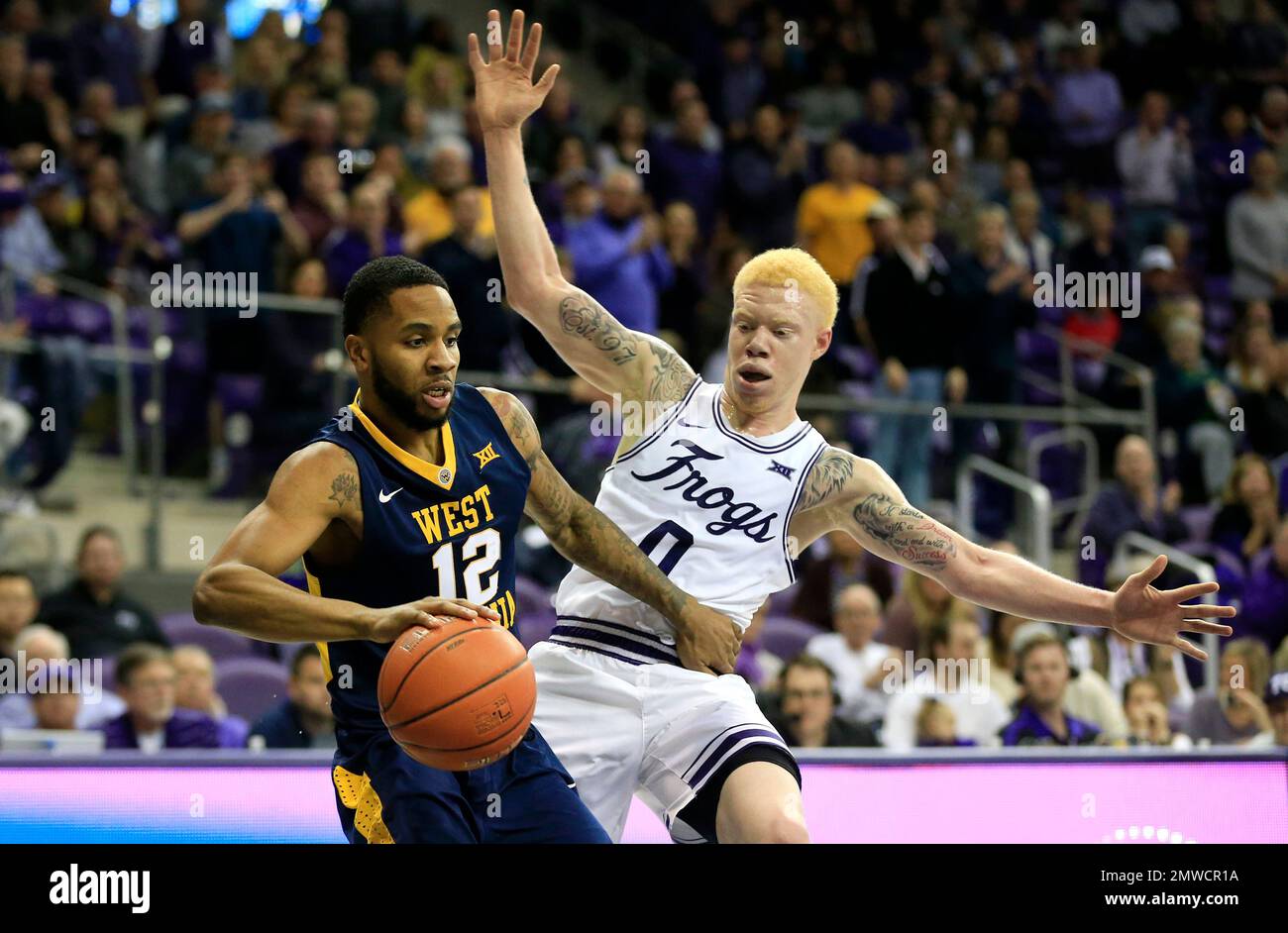 West Virginia guard Tarik Phillip (12) dribbles inside as TCU guard ...