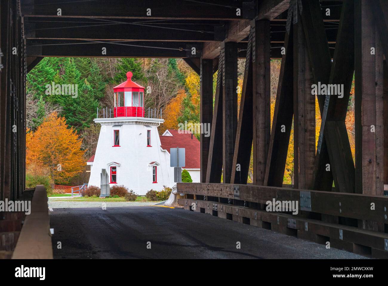 The lighthouse framed by a covered bridge at St. Martins, New Brunswick ...