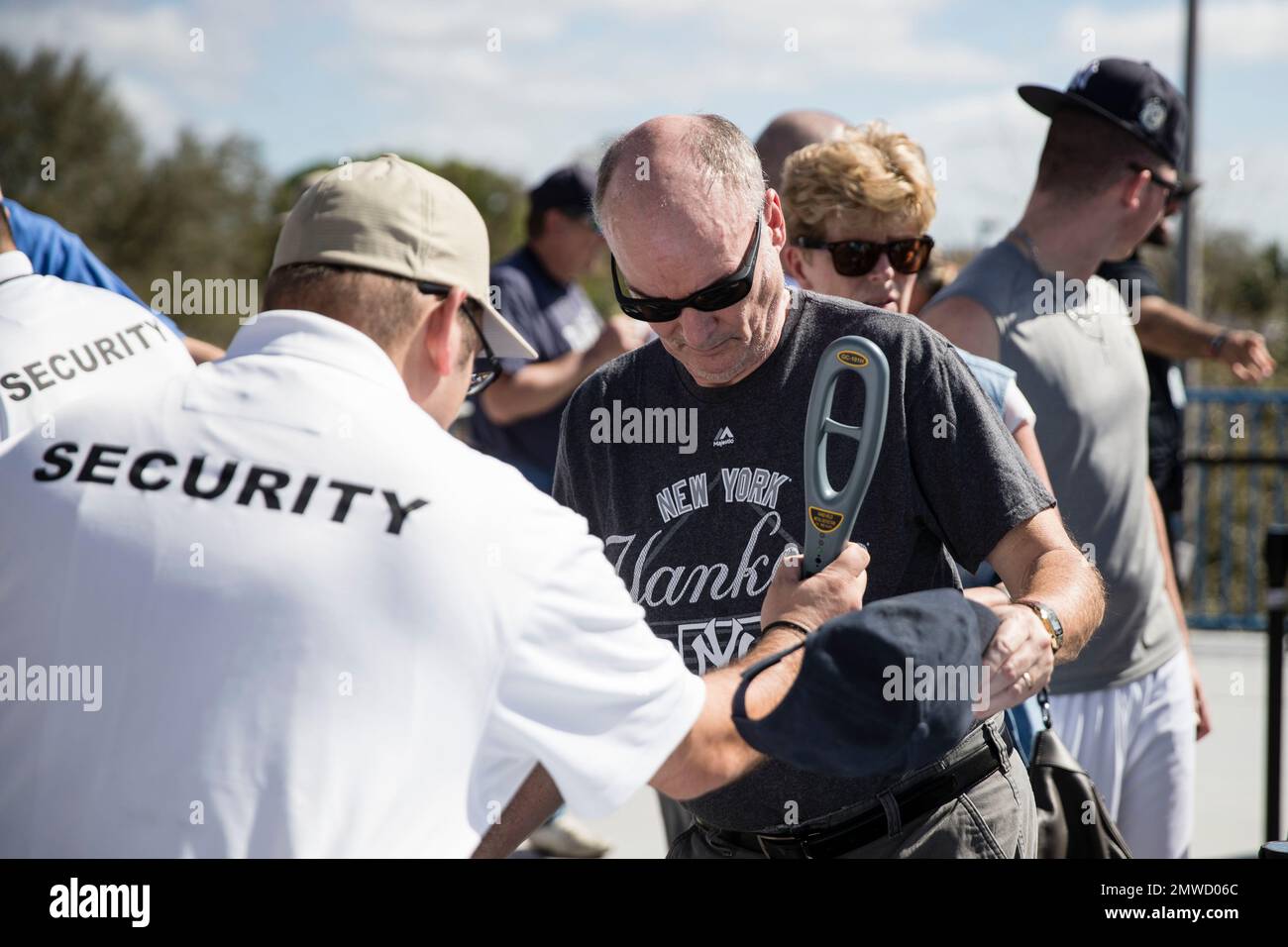 A security official scans a fan ahead of a spring training baseball ...