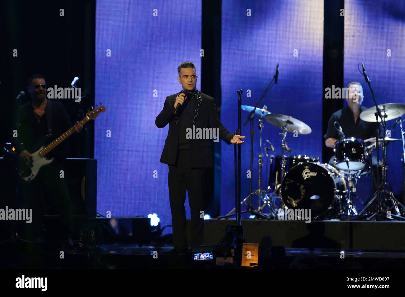 Singer Robbie Williams gestures to sound technicians to turn on his ...