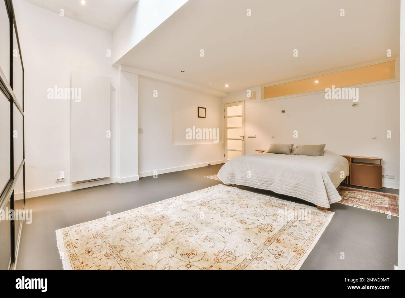 a bedroom with an area rug on the floor in front of the bed and door to ...