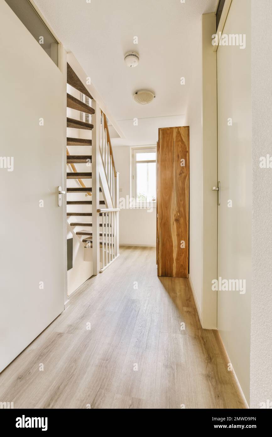 an empty room with wood flooring and wooden staircase leading up to the ...