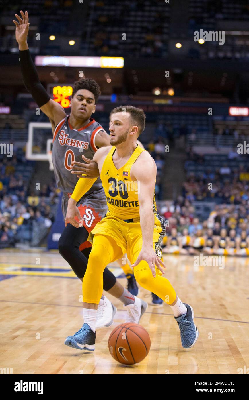 Marquette's Andrew Rowsey (30) drives against St. John's Malik Ellison ...