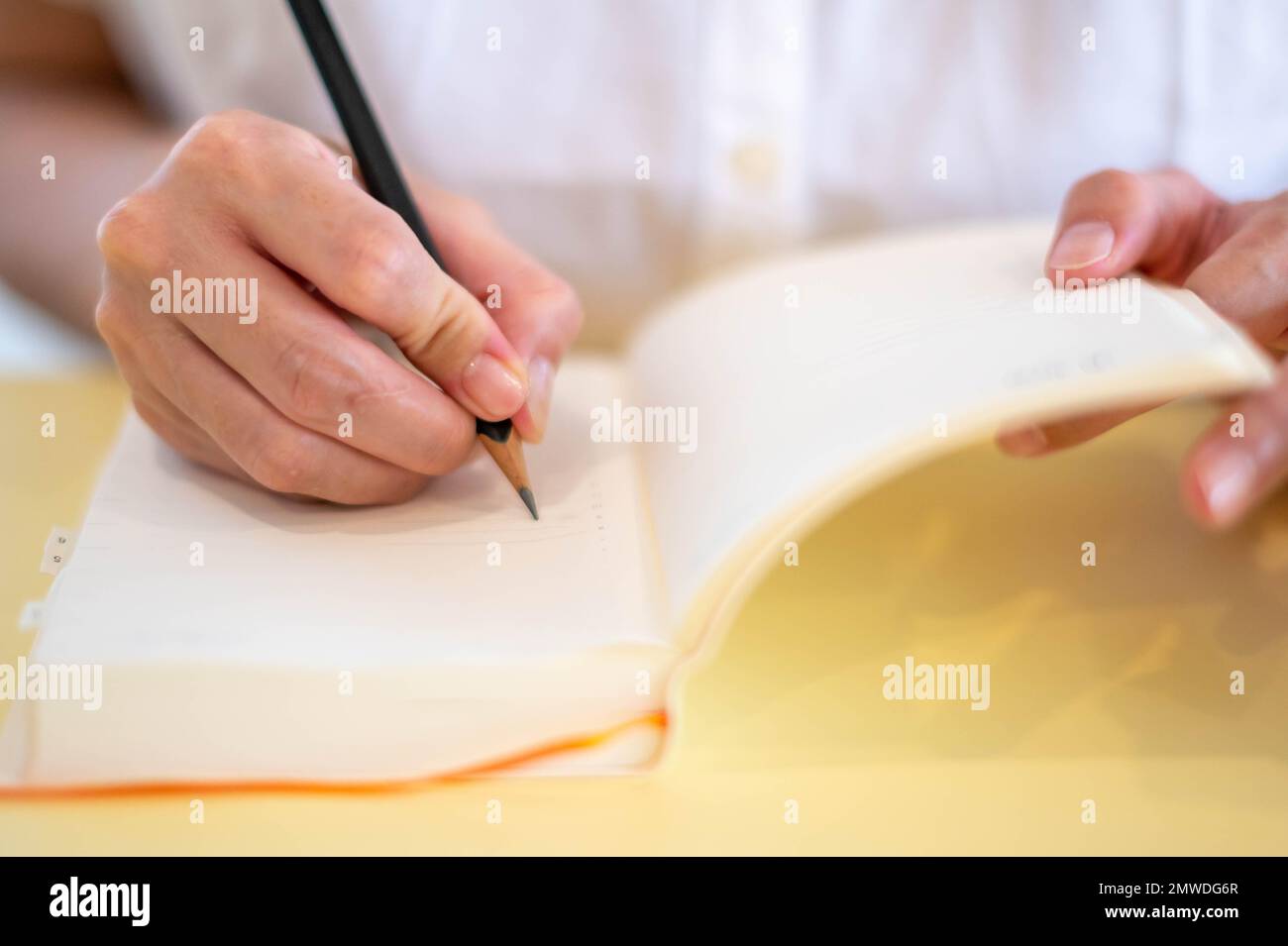 Females hand making notes with pencils and empty notebooks in their ...