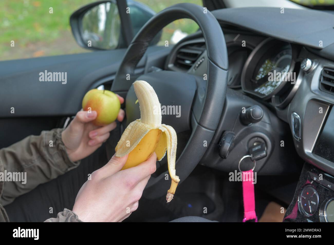 Symbol photo, eating while driving, driving a car Stock Photo - Alamy