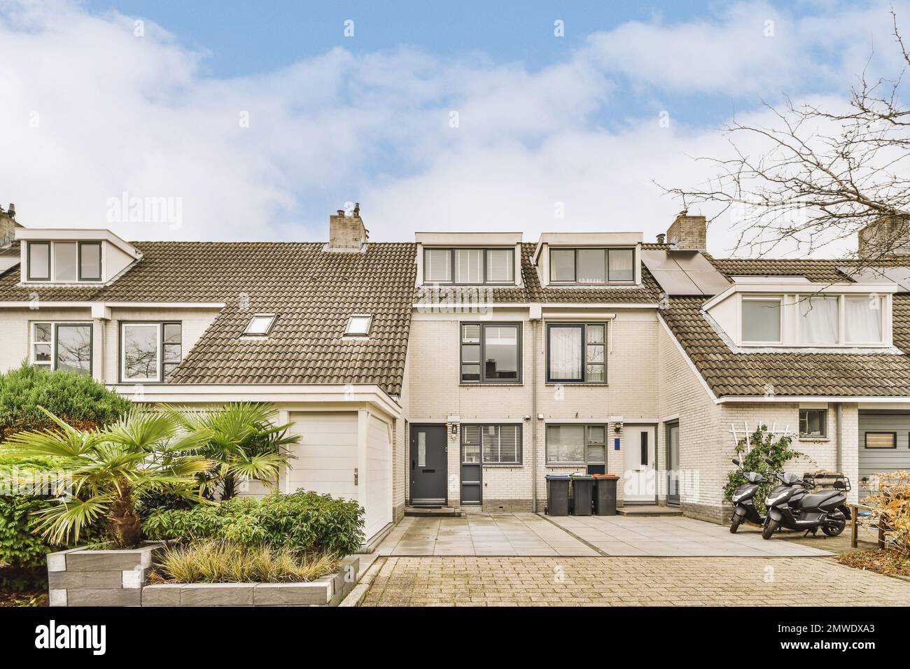 a house in the middle of a street with cars parked on both sides and ...