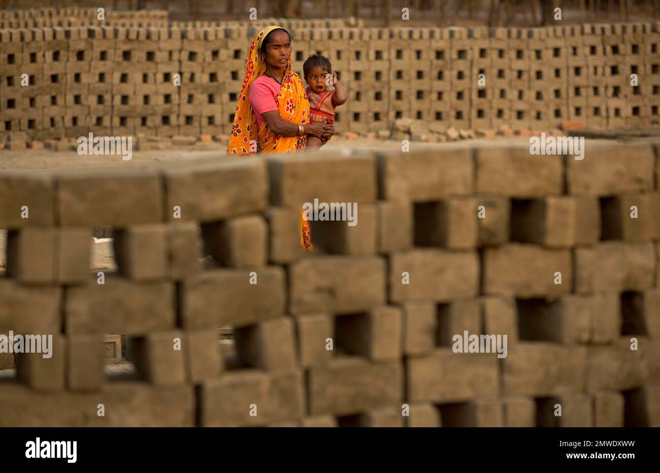 An Indian woman laborer carries her child at a brick kiln on the ...