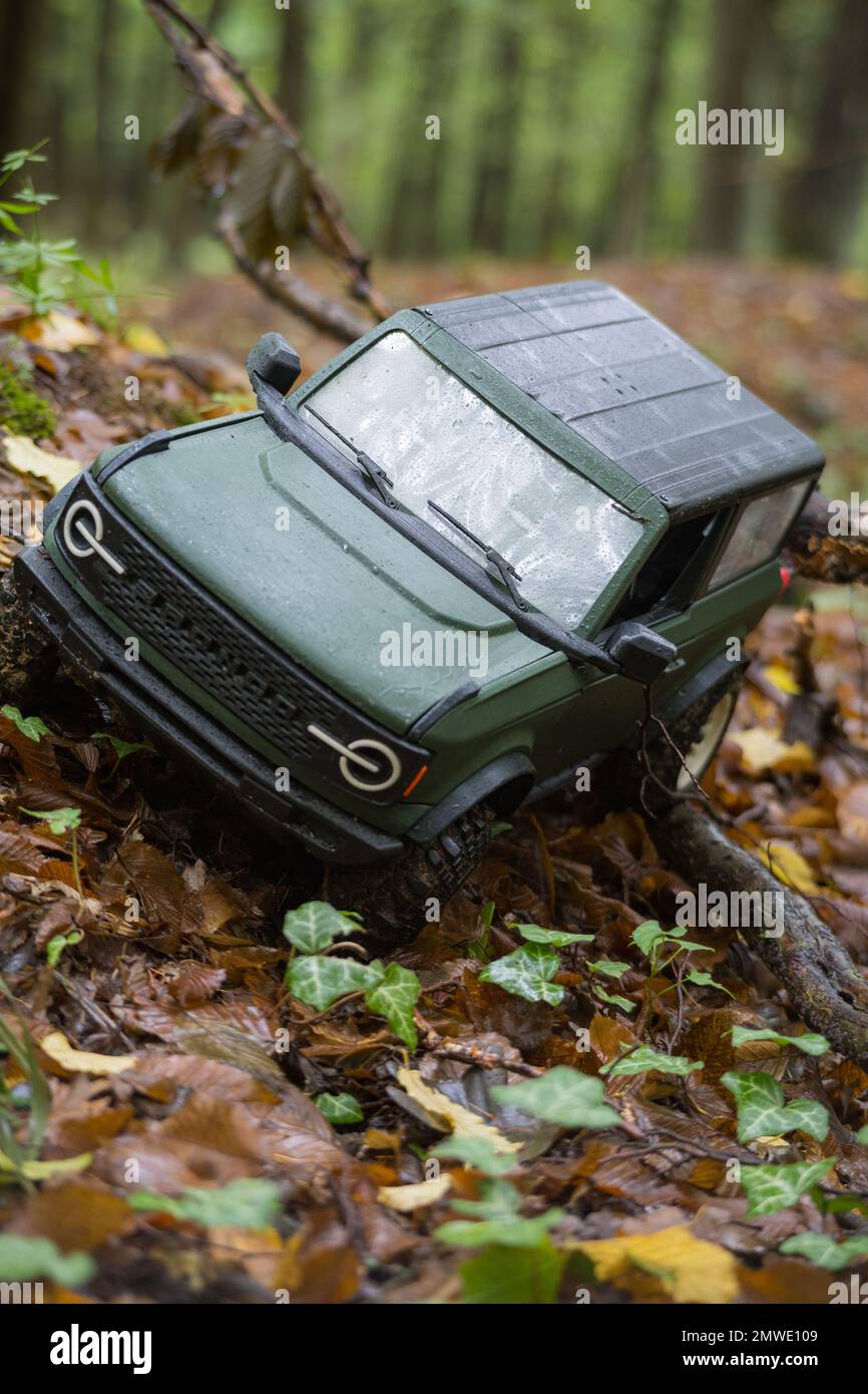 A vertical shot of a 3D printed Ford Bronco RC car model in a forest ...