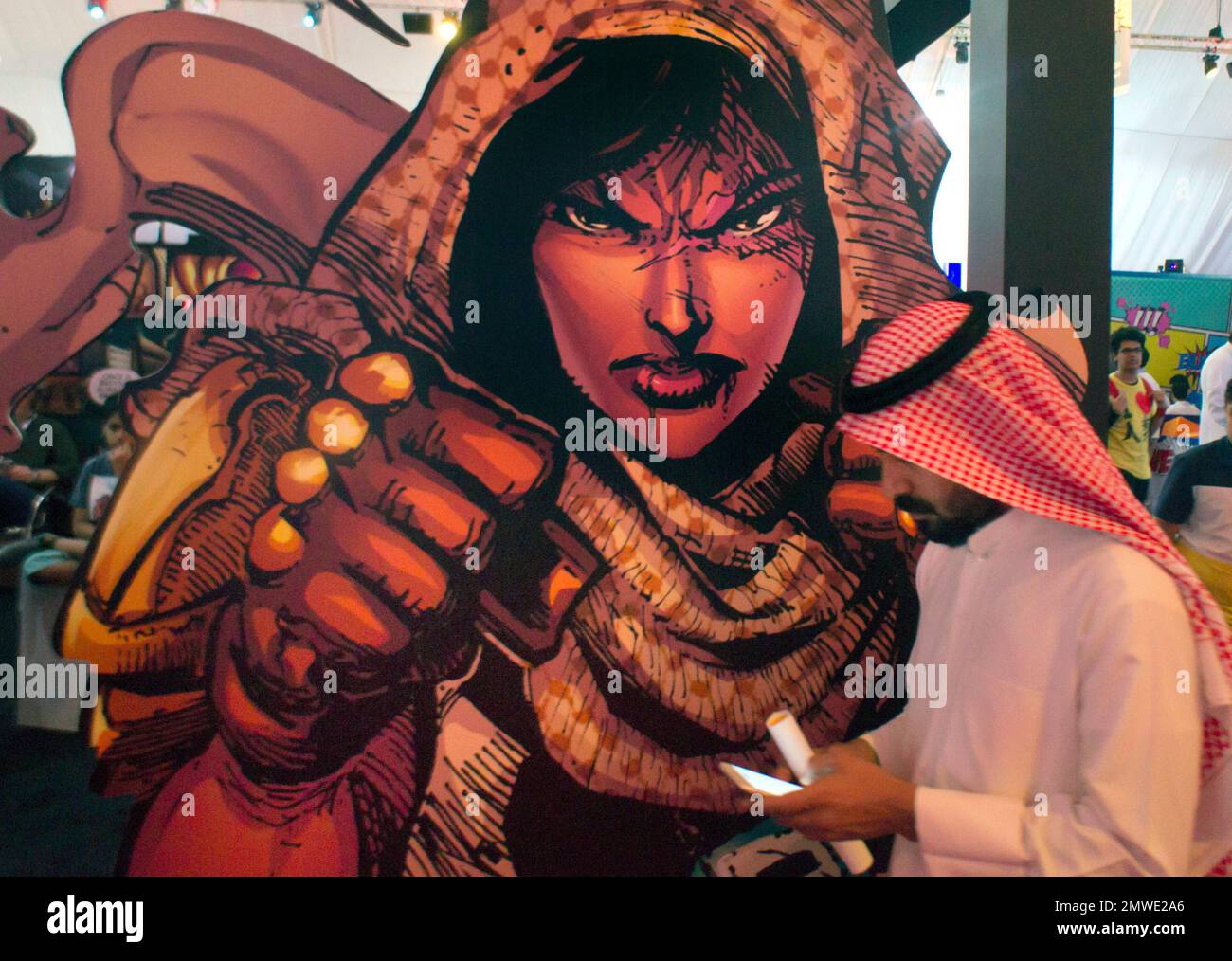 A visitor walks past a banner showing Latifa, Saudi super woman ...