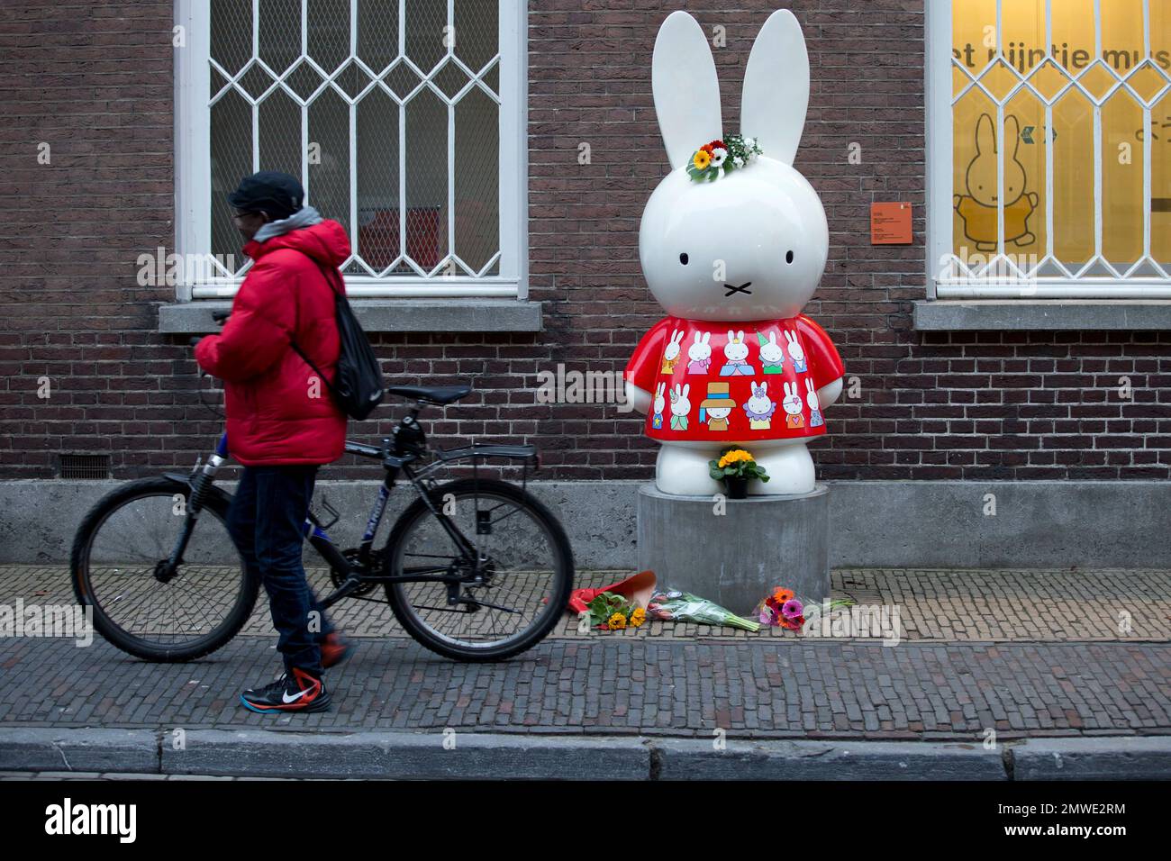 A man passes a statue of Miffy adorned with flowers outside the Nijntje ...