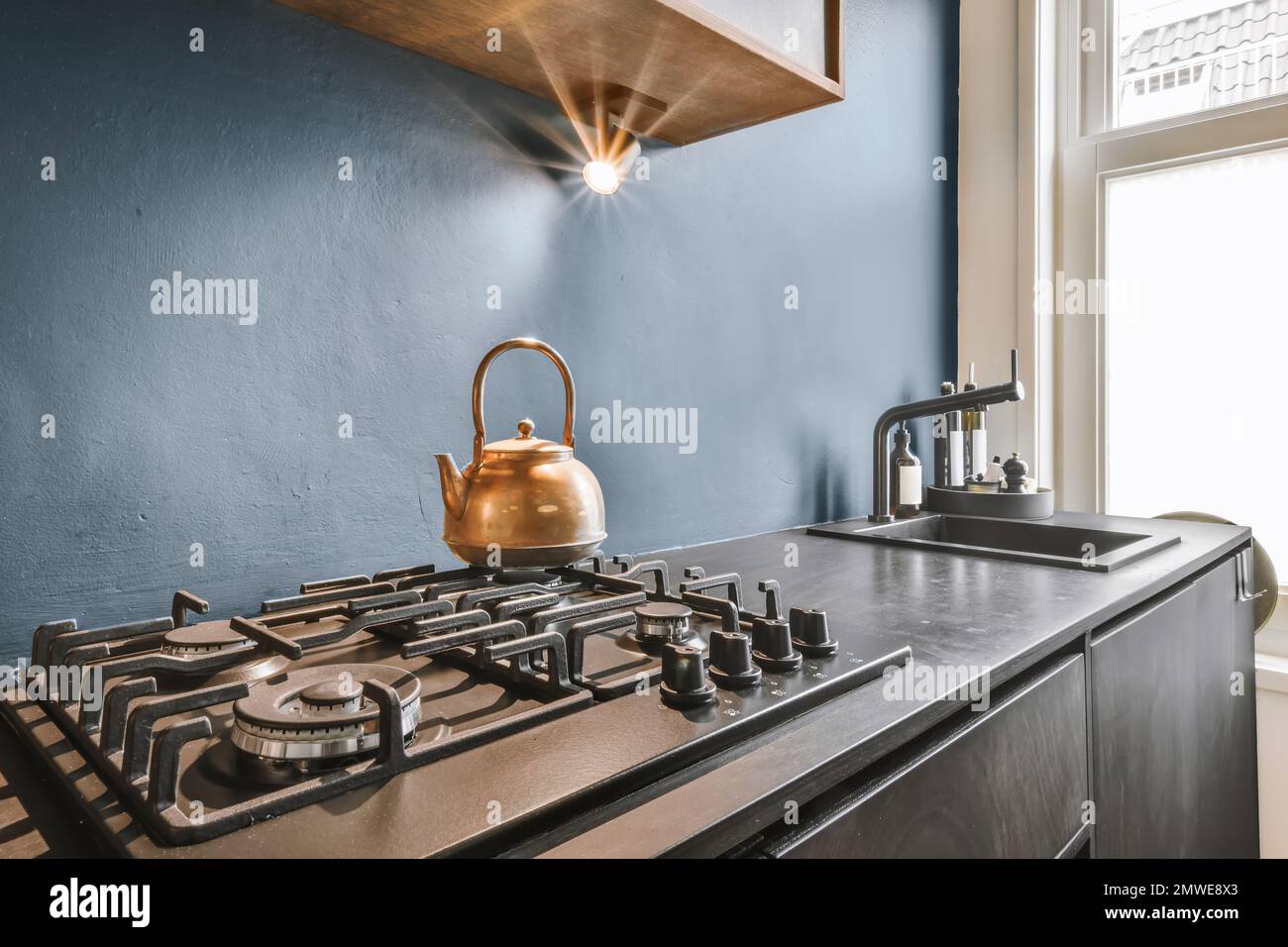 a kitchen with a tea kettle on the stove top and blue walls in the ...