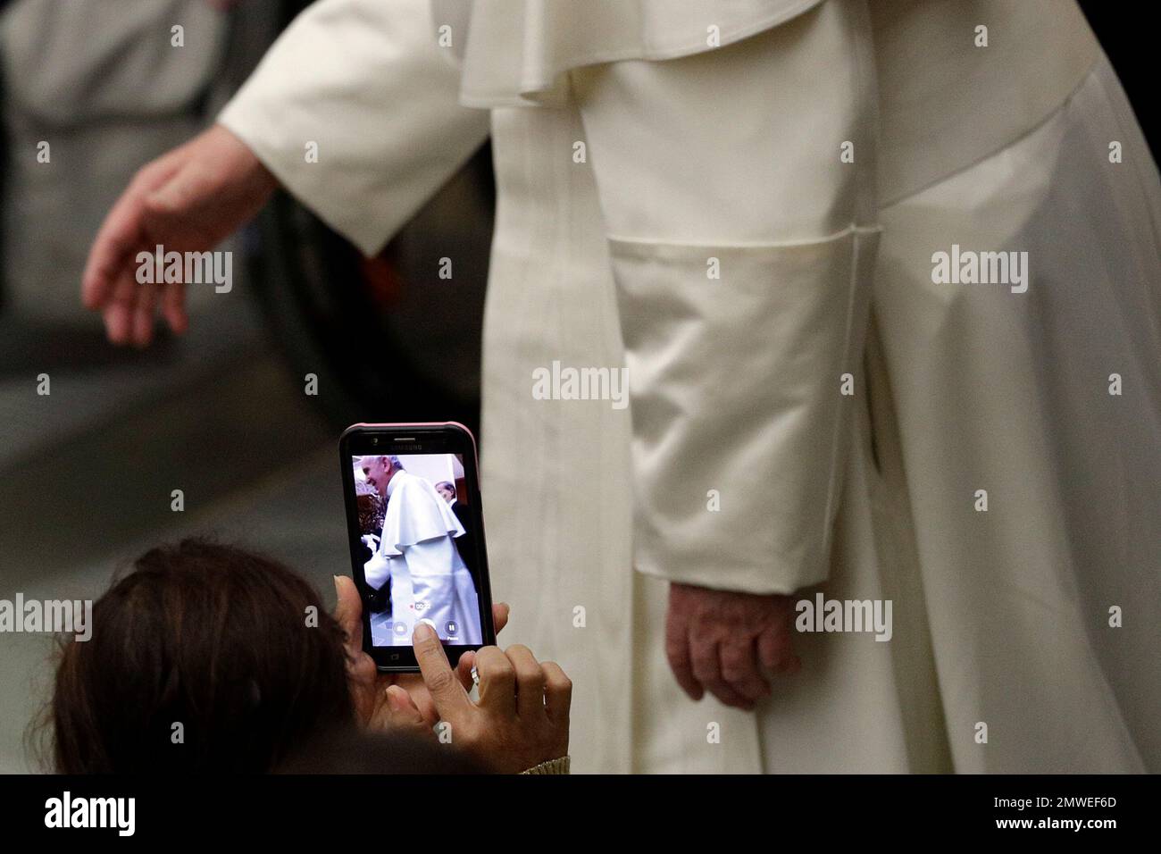 A woman uses her mobile phone to take pictures of Pope Francis during ...