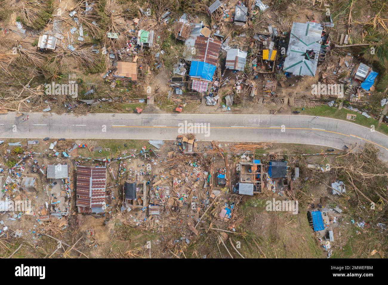 An aerial shot of a road in the middle of destroyed buildings on dry ...