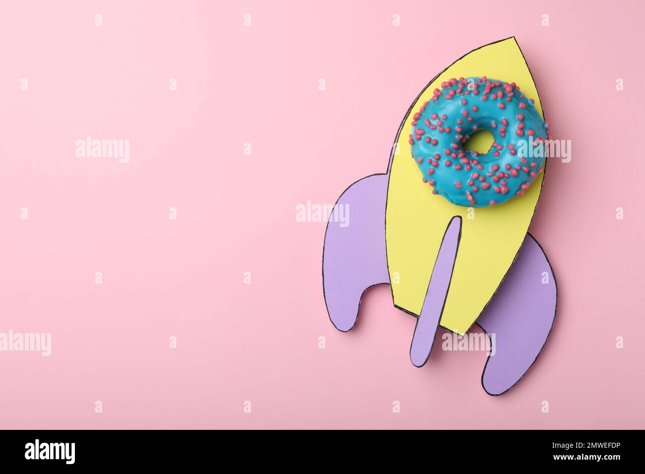 Rocket made with donut and paper on pink background, top view. Space ...