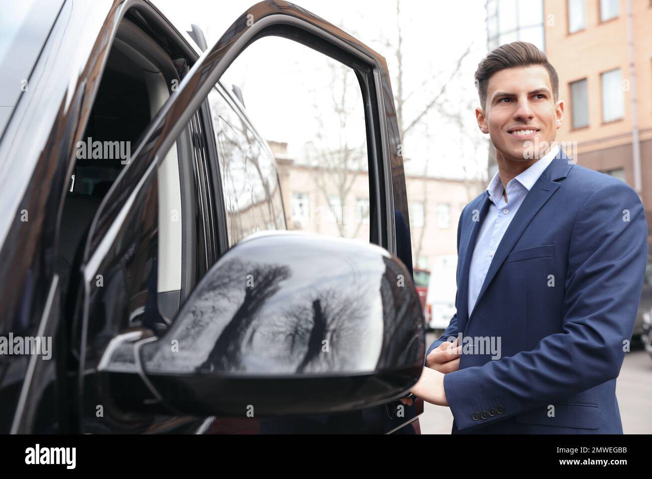 Smiling man opening car city street hi-res stock photography and images ...