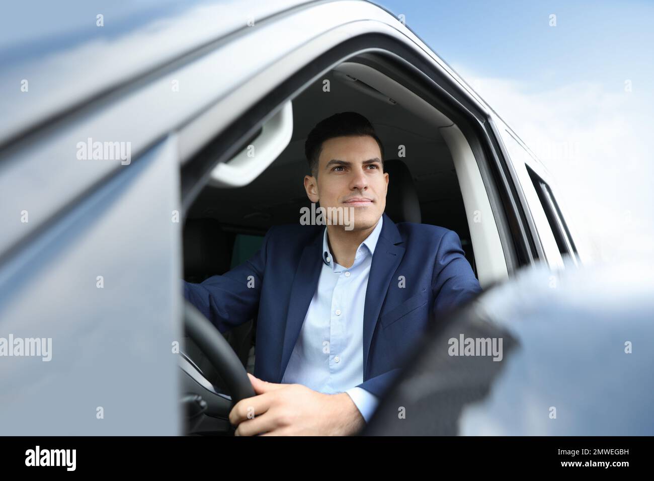 Handsome man driving his modern car, view from outside Stock Photo - Alamy