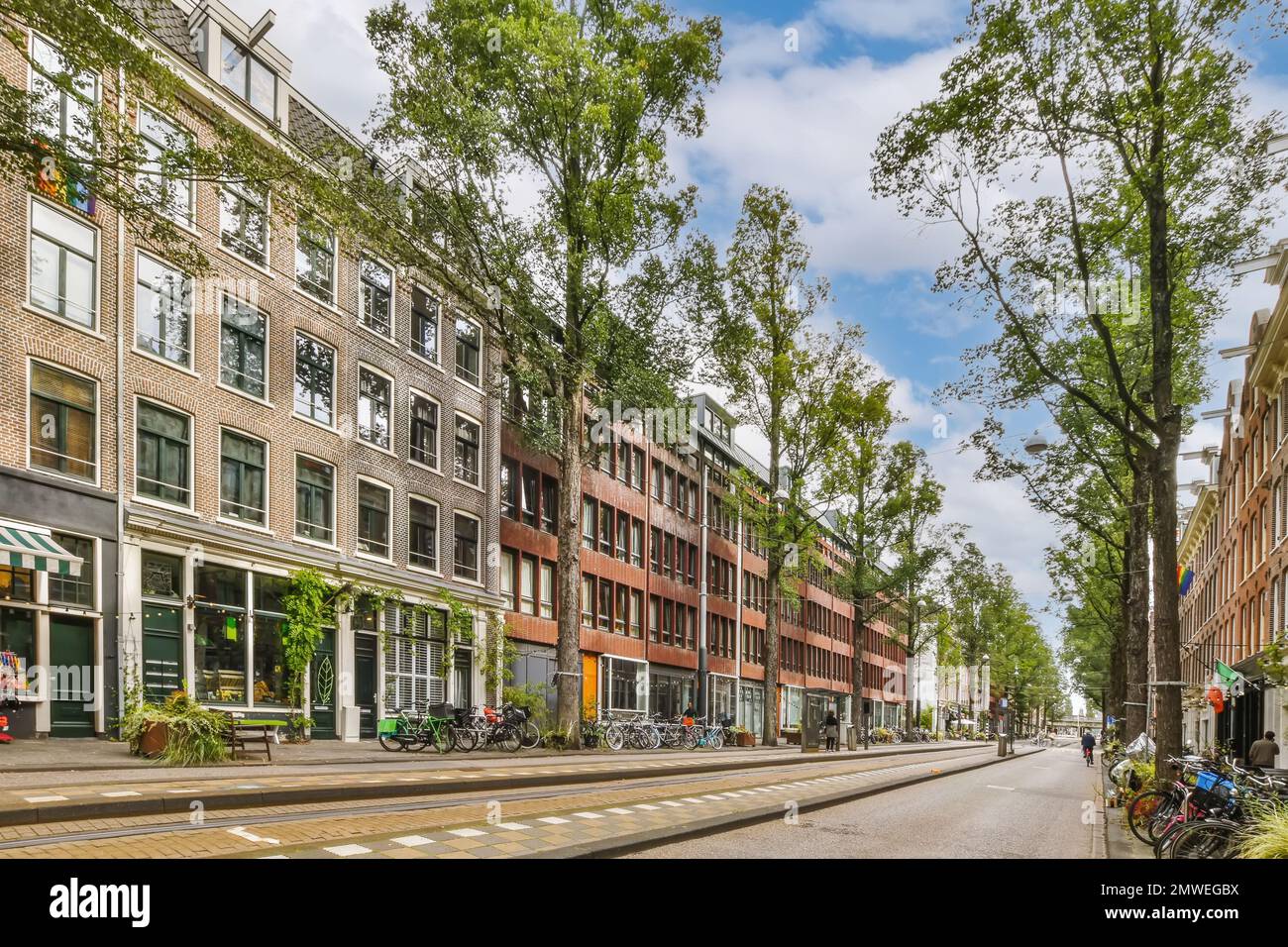 an empty street in amsterdam, with bikes parked on the side and people ...