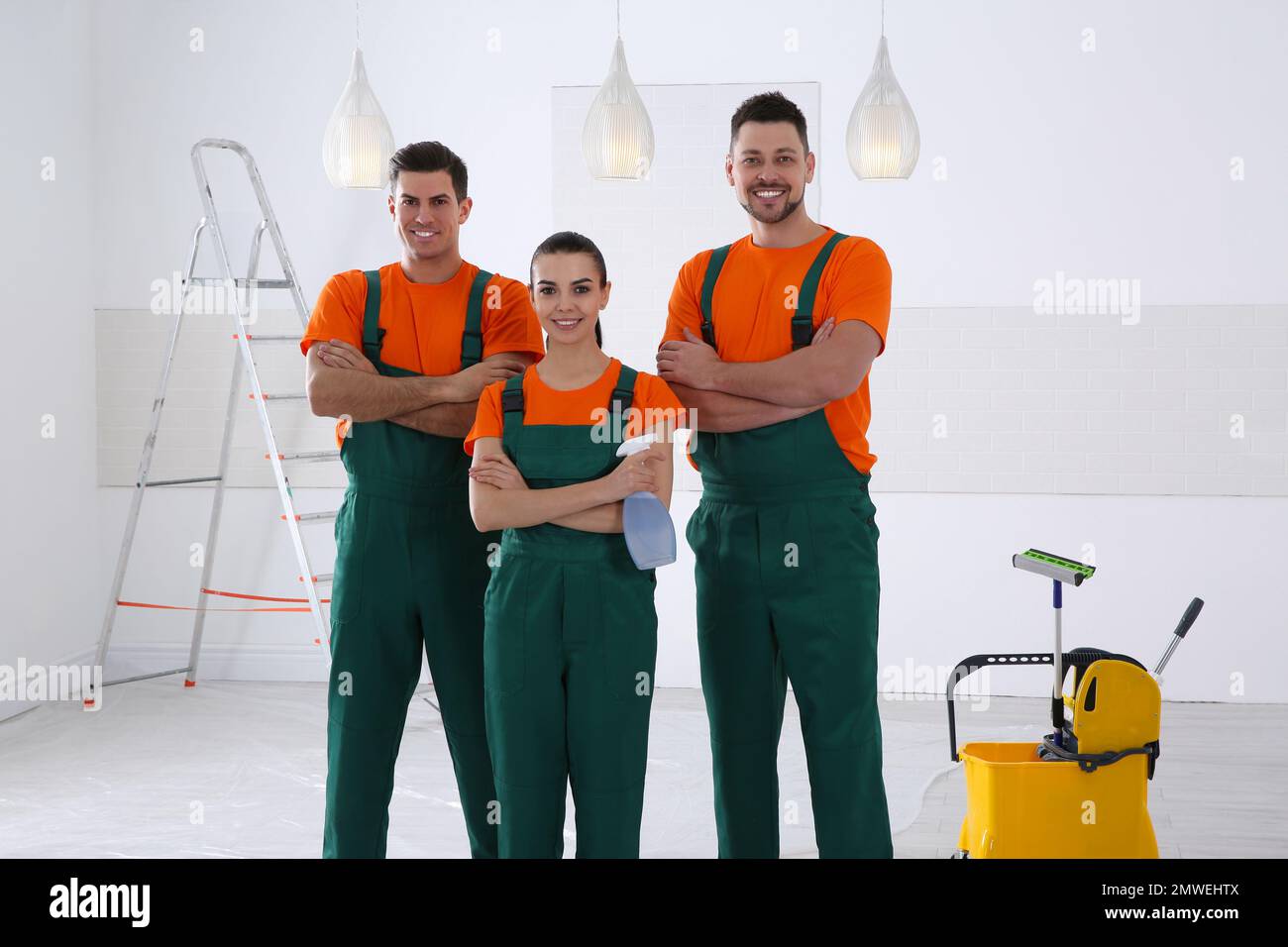 Team of professional janitors in uniform indoors. Cleaning service ...