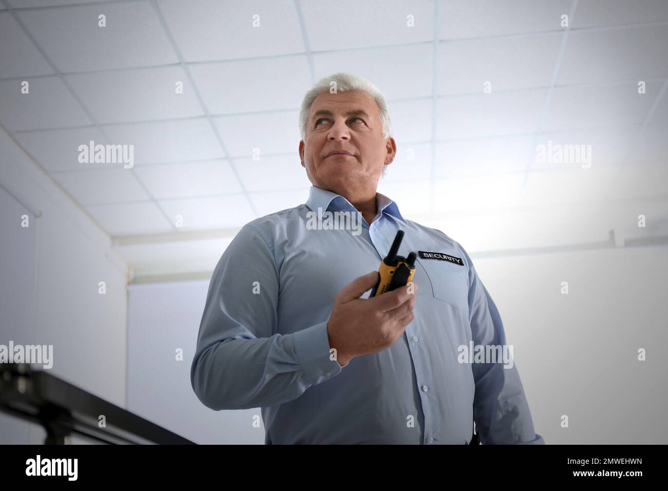 Professional security guard with portable radio set indoors Stock Photo ...