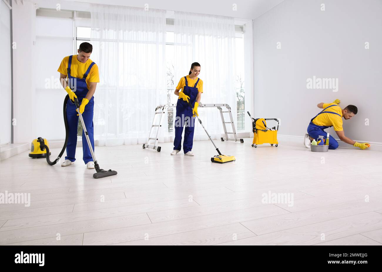 Team of professional janitors cleaning room after renovation Stock ...