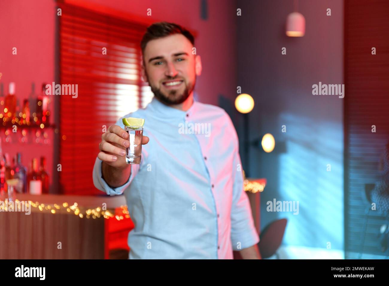 Young man with Mexican Tequila shot in bar Stock Photo - Alamy