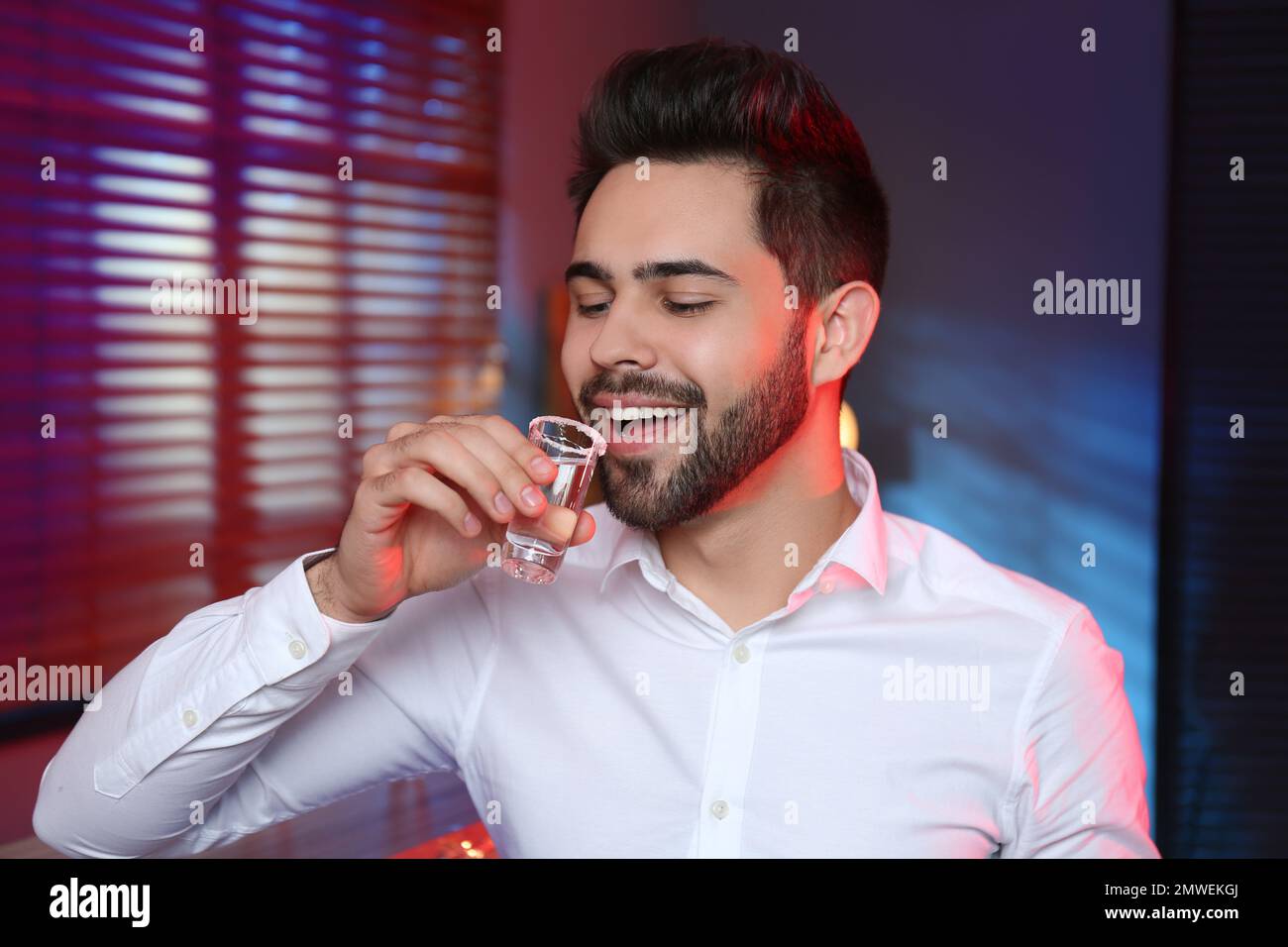 Young man with Mexican Tequila shot in bar Stock Photo - Alamy