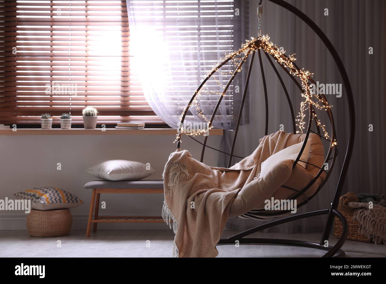 Cozy hanging chair with fairy lights in modern living room. Interior ...