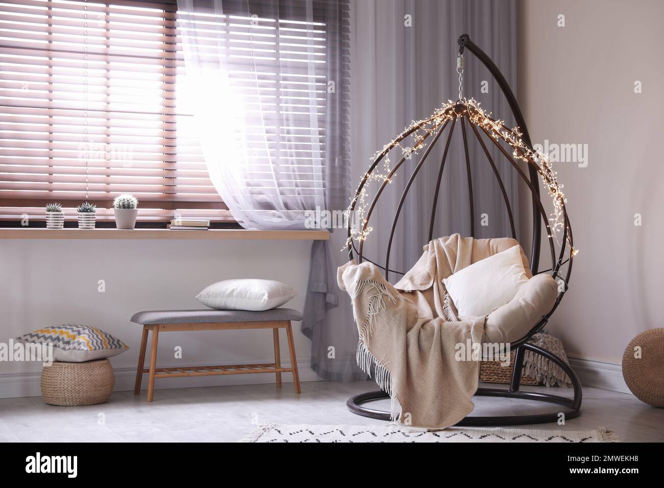 Cozy hanging chair with fairy lights in modern living room. Interior ...