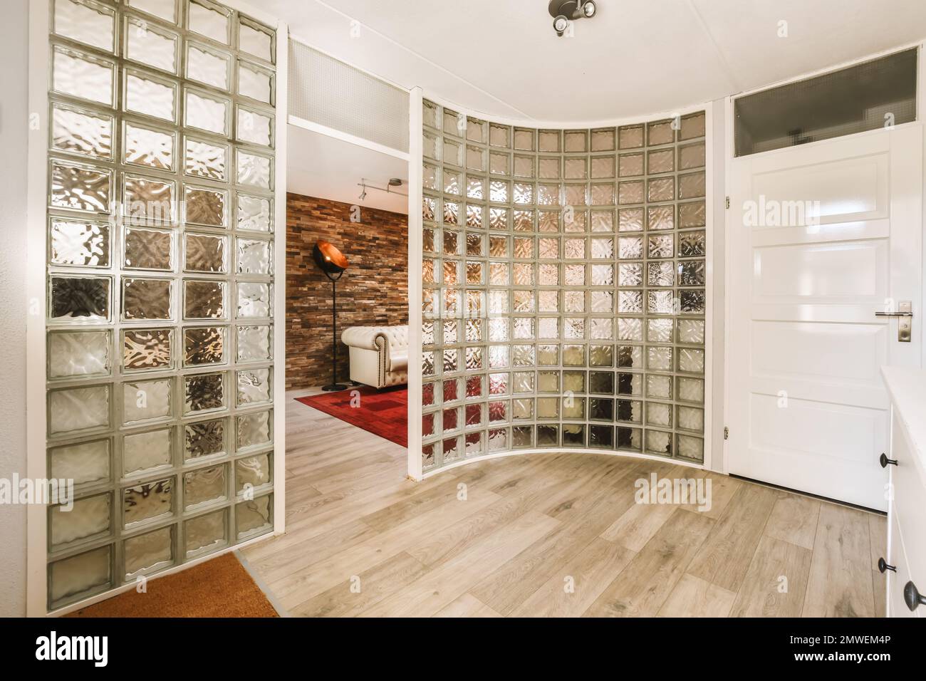 a living room with wood flooring and glass partitions on the wall to ...