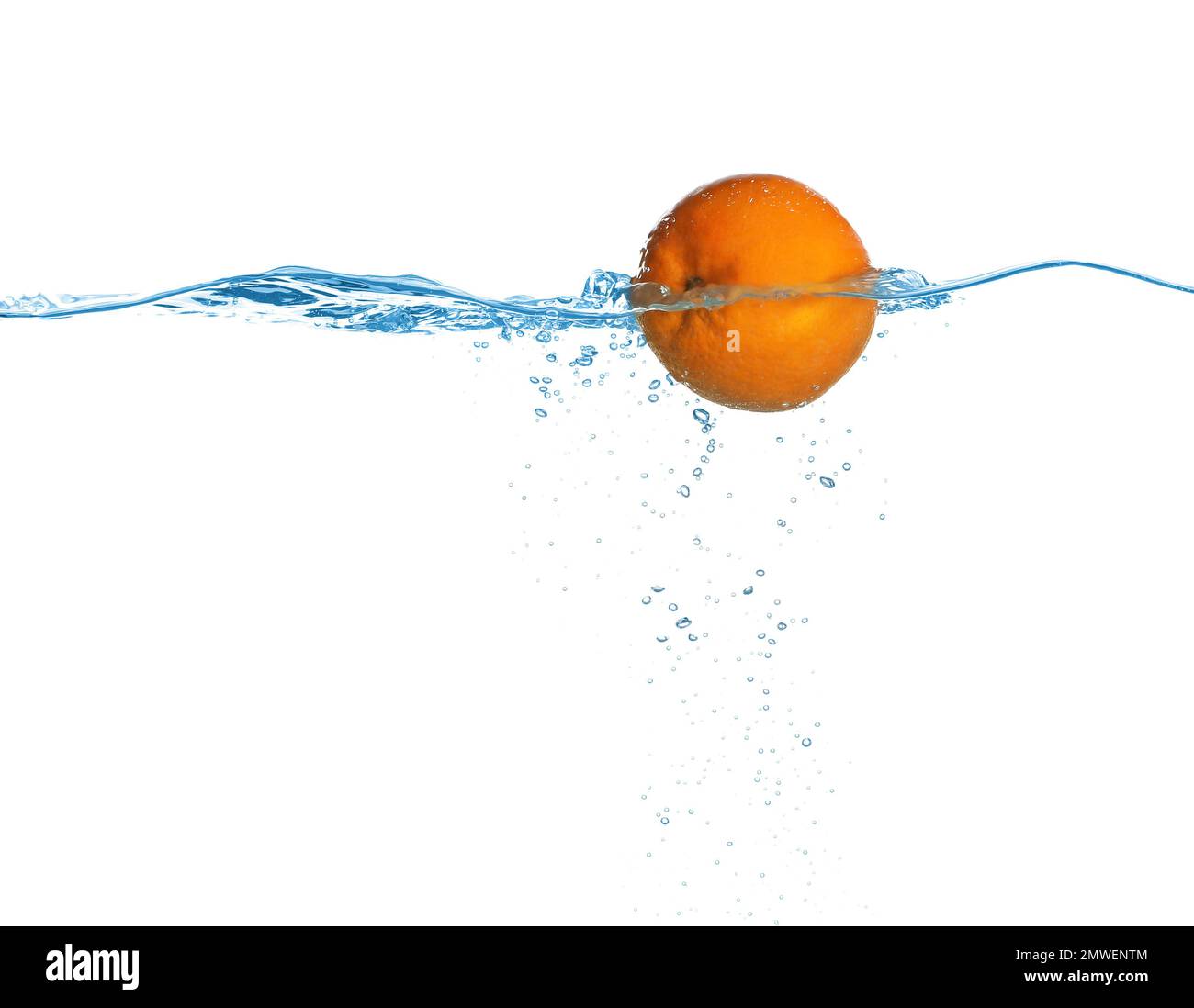 Ripe orange falling down into clear water against white background ...