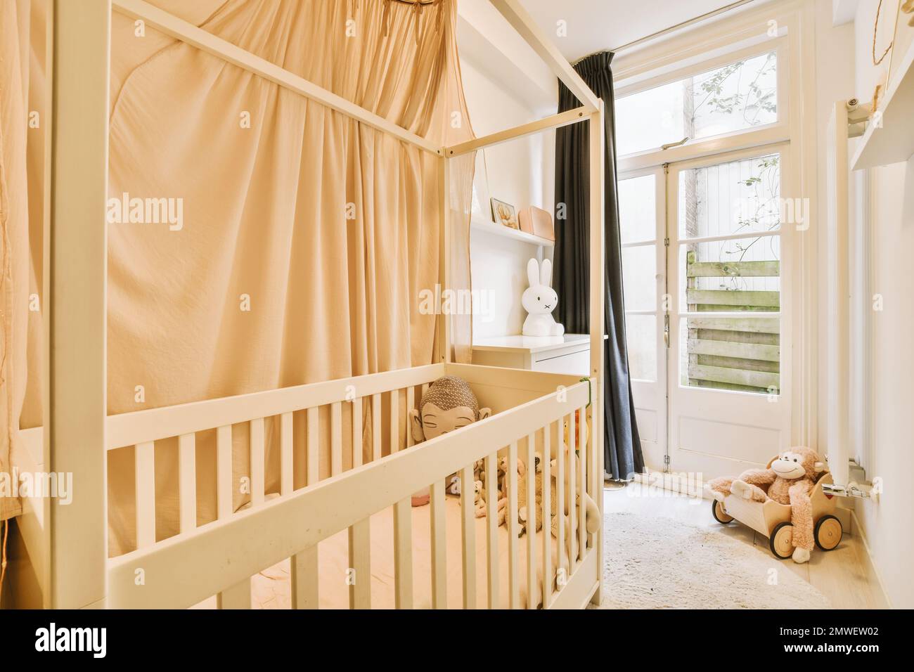 a baby's room with a cribt and teddy bear on the floor next to the ...