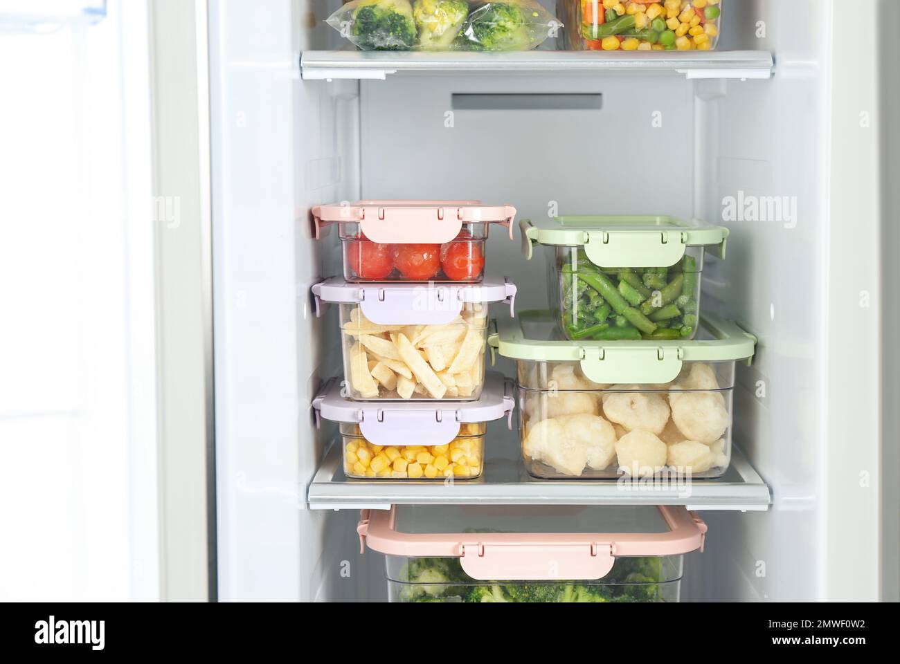 Containers with different frozen vegetables in refrigerator Stock Photo ...
