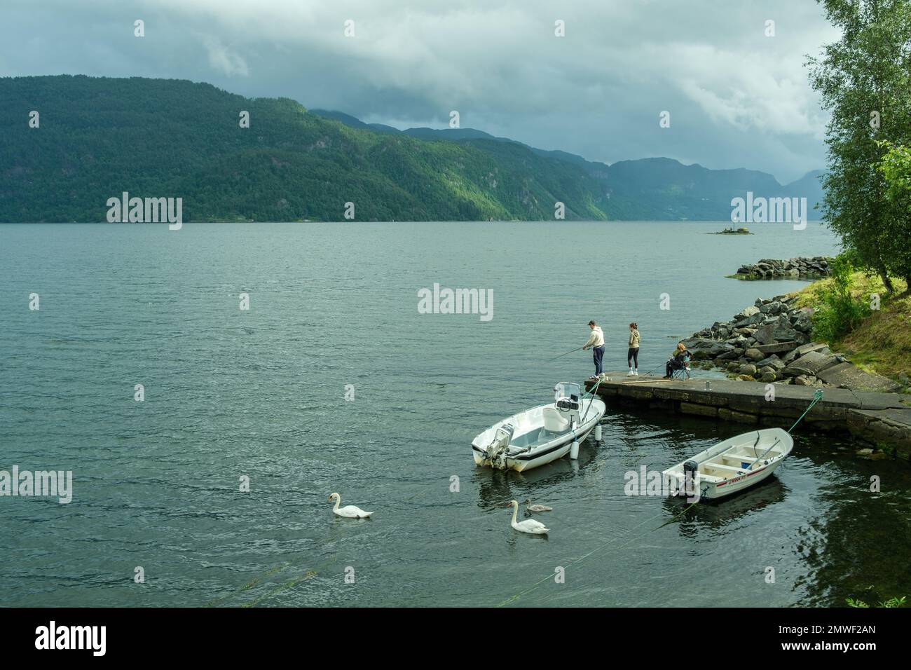 A high angle shot of people fishing in the fjord in Sauda, Norway Stock ...