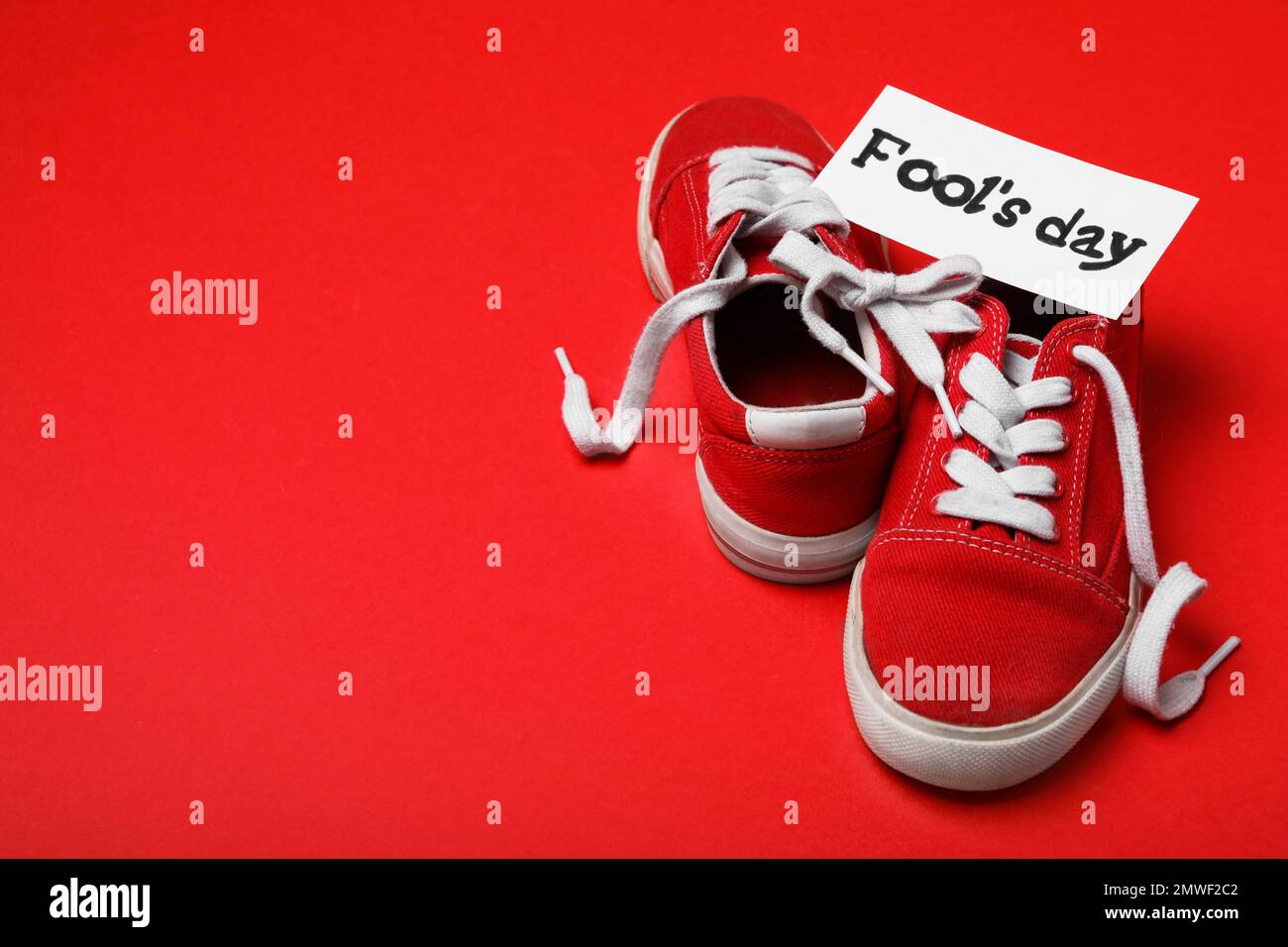 Shoes tied together and note with phrase FOOL'S DAY on red background ...