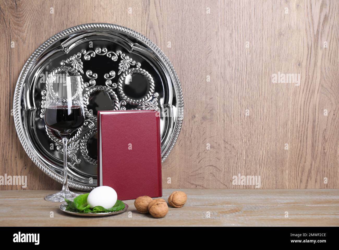 Symbolic Pesach (Passover Seder) items on wooden table, space for text ...