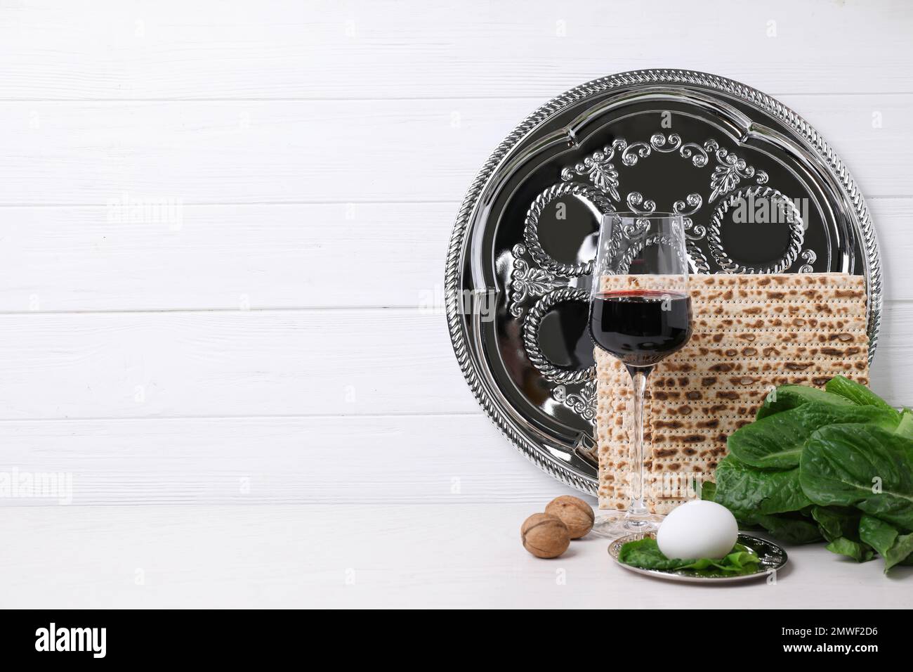 Symbolic Pesach (Passover Seder) items on white table, space for text ...