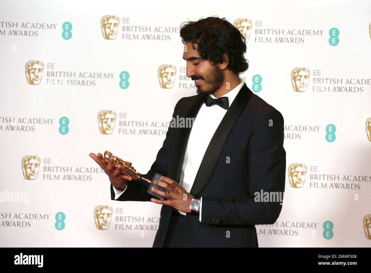 Actor Dev Patel poses for photographers with his BAFTA award for Best ...