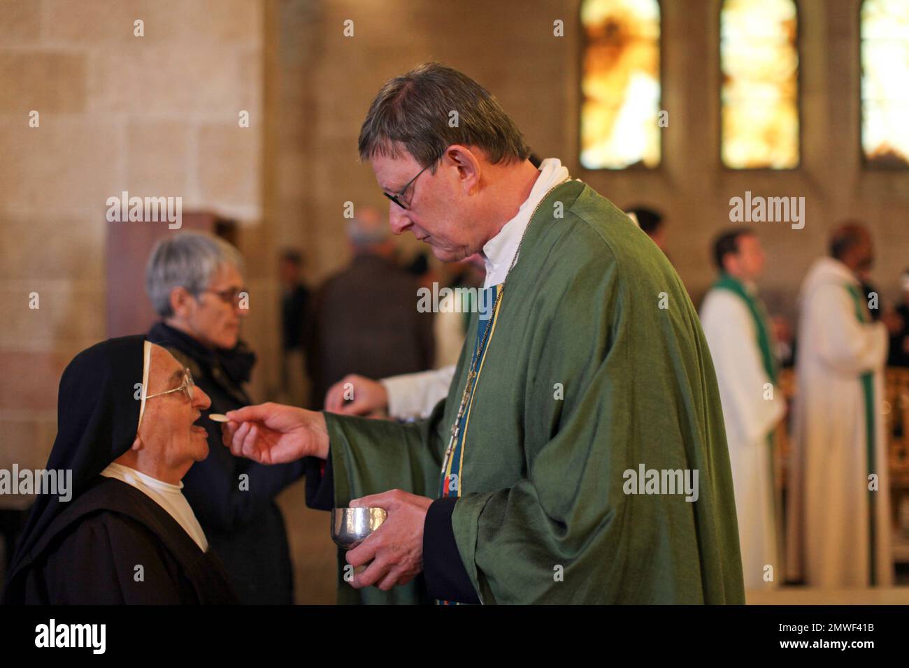 A priest gives communion during a special Mass at the Church of the ...