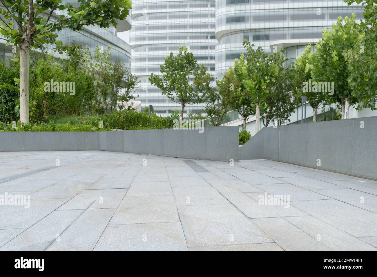 A beautiful view of an empty tiled pavement in front of modern office ...