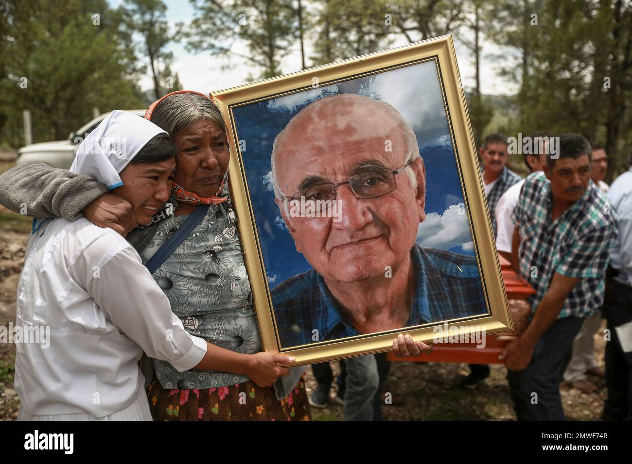 FILE - Women hold a portrait of Jesuit priest Javier Campos Morales as ...