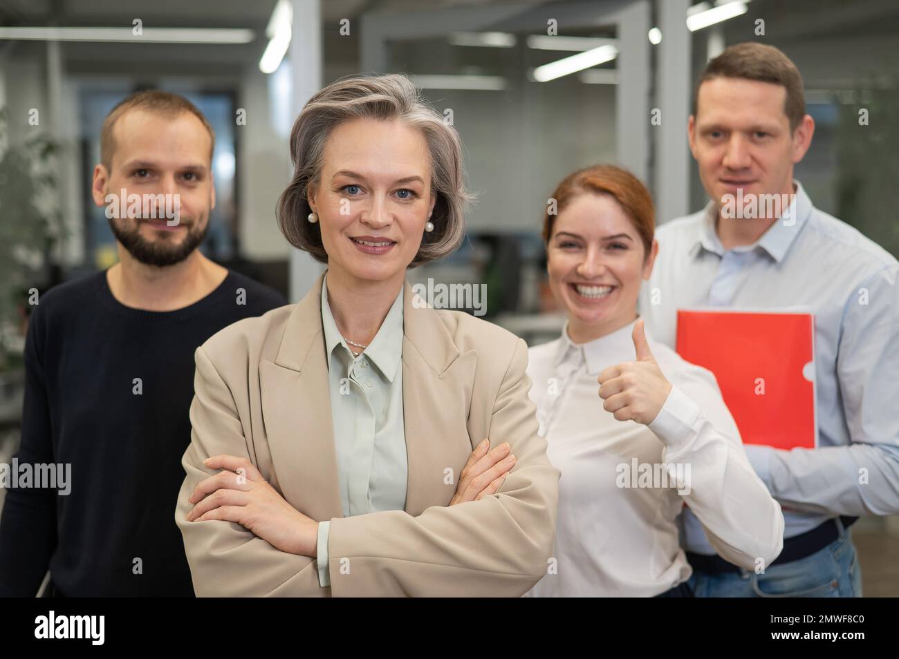 Portrait of four office workers. A gray-haired mature woman, a ...