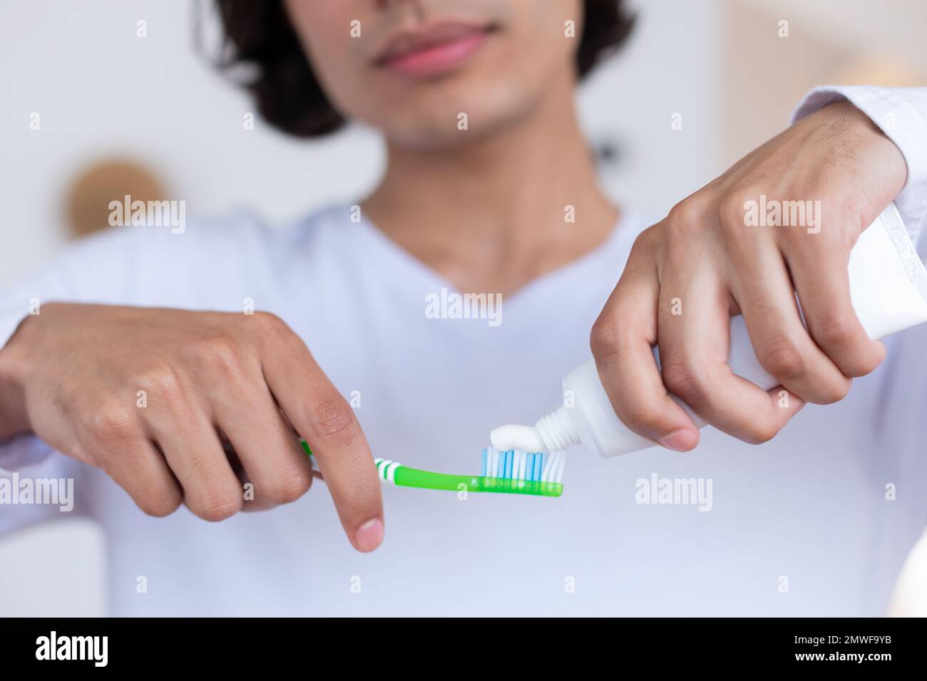 Happy biracial man brushing teeth in bathroom Stock Photo - Alamy