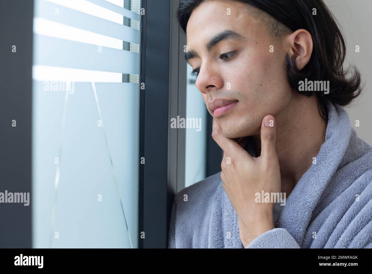 Biracial man looking through window Stock Photo - Alamy